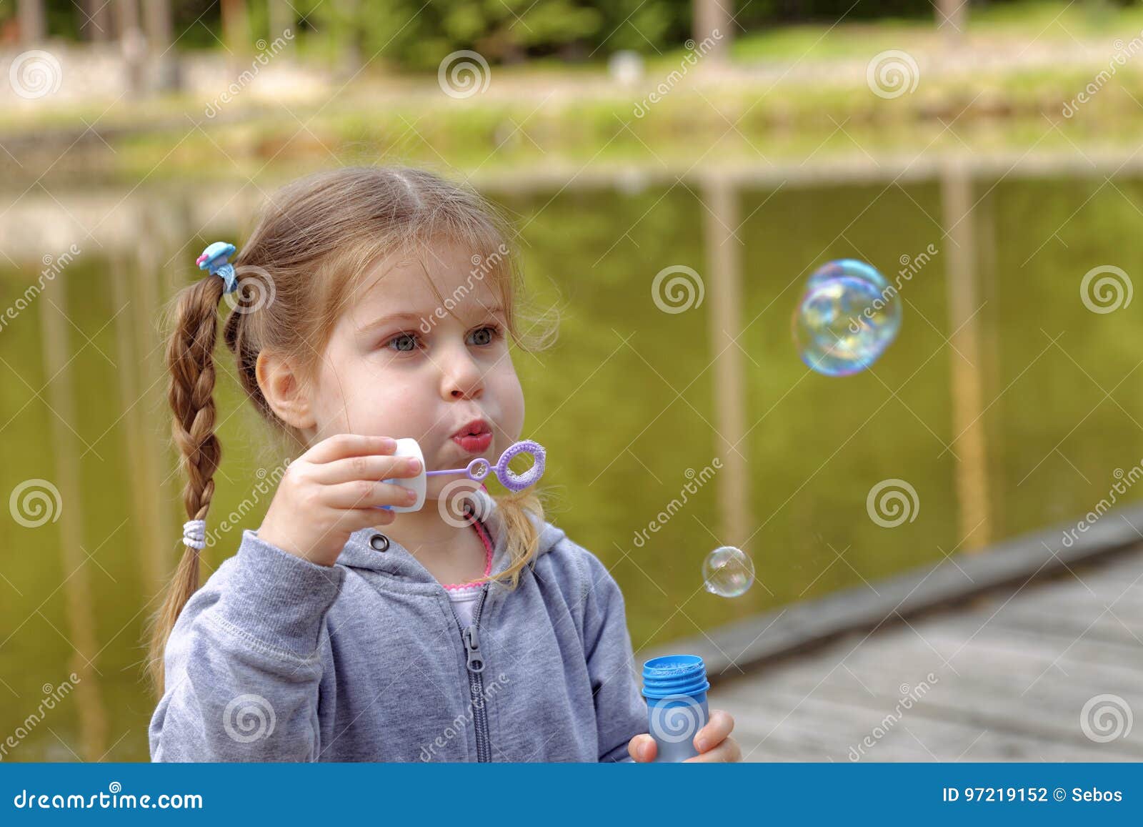 Adorable Little Girl Blowing Bubbles in the Park Stock Photo - Image of ...