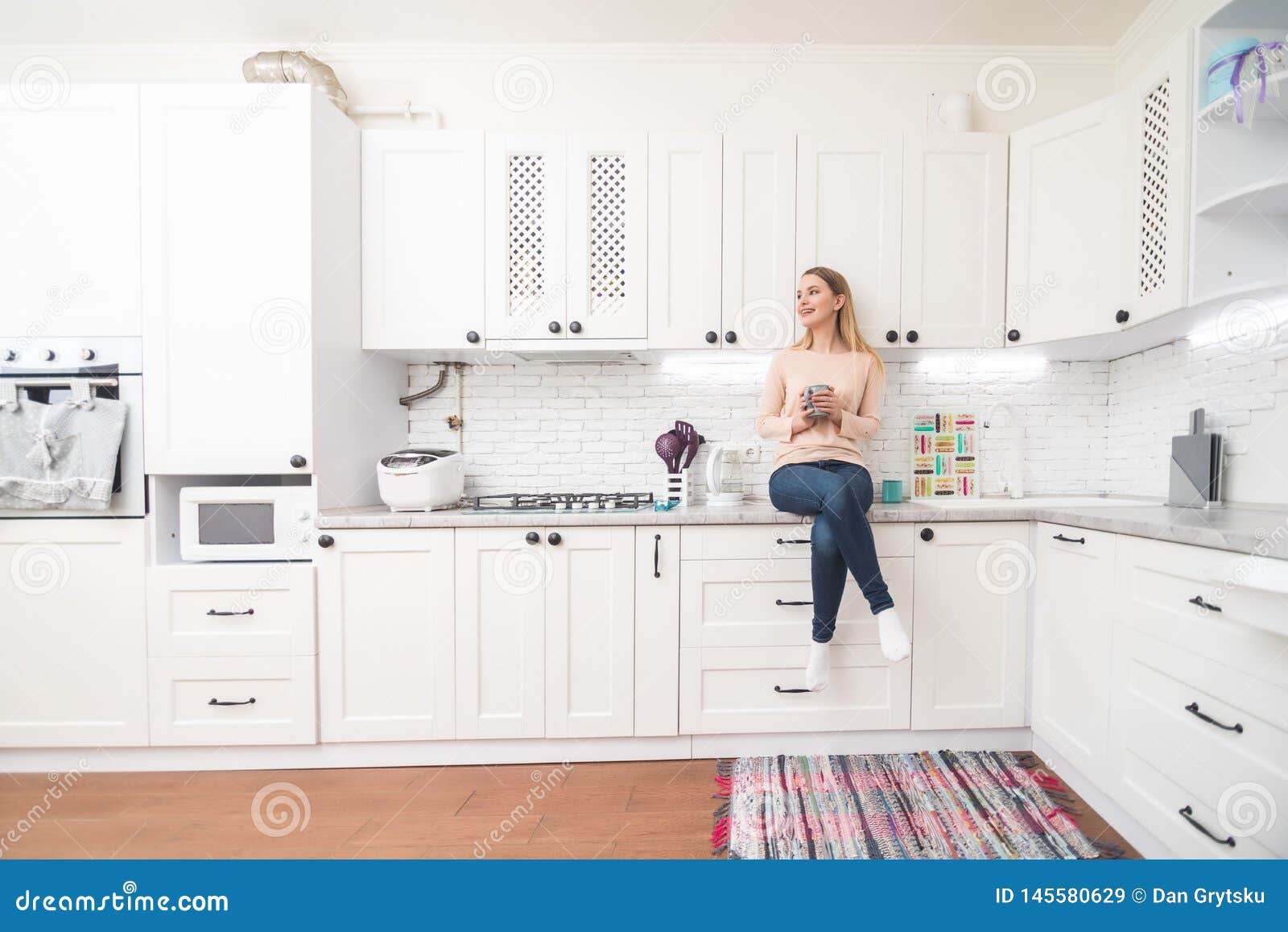 Adorable Nice Girl Drinking Coffee, Sitting on Table Countertop in ...