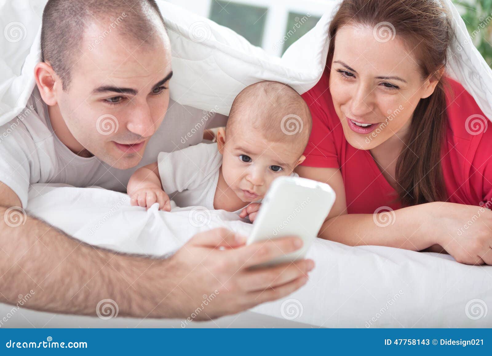 Adorable Smiling Family Using Mobile at Home Stock Image - Image of ...
