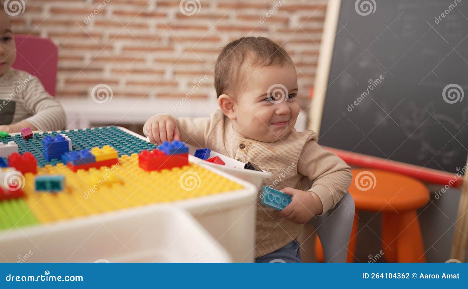 Adorable Toddler Holding Plastic Construction Blocks Sitting on Table ...
