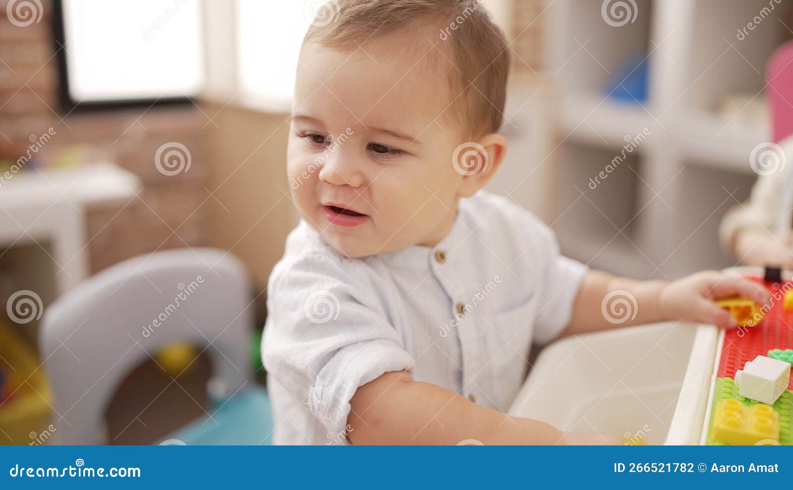 Adorable Toddler Holding Plastic Construction Blocks Sitting on Table ...
