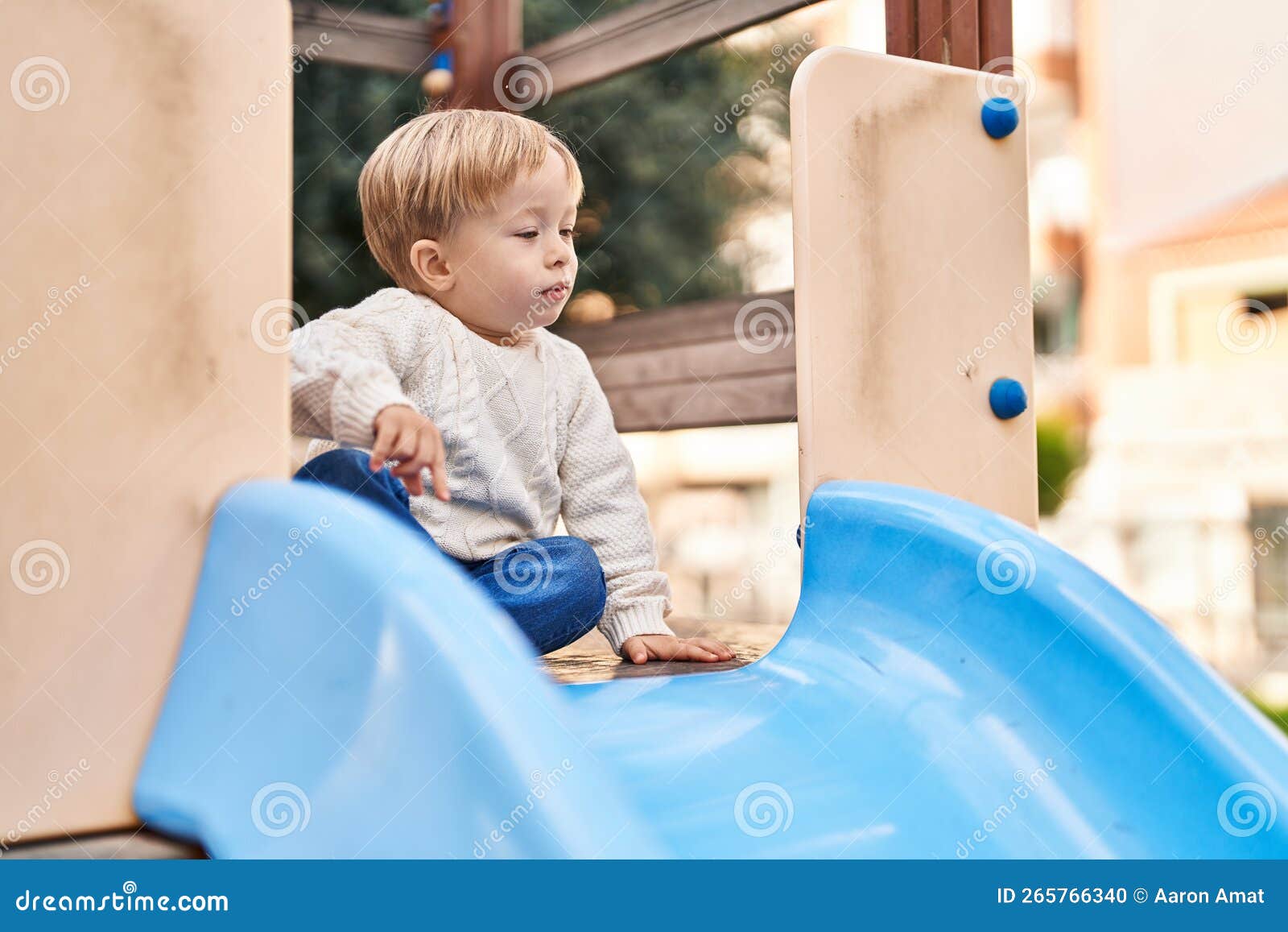 Adorable Toddler Sitting on Slide at Park Stock Photo - Image of ...
