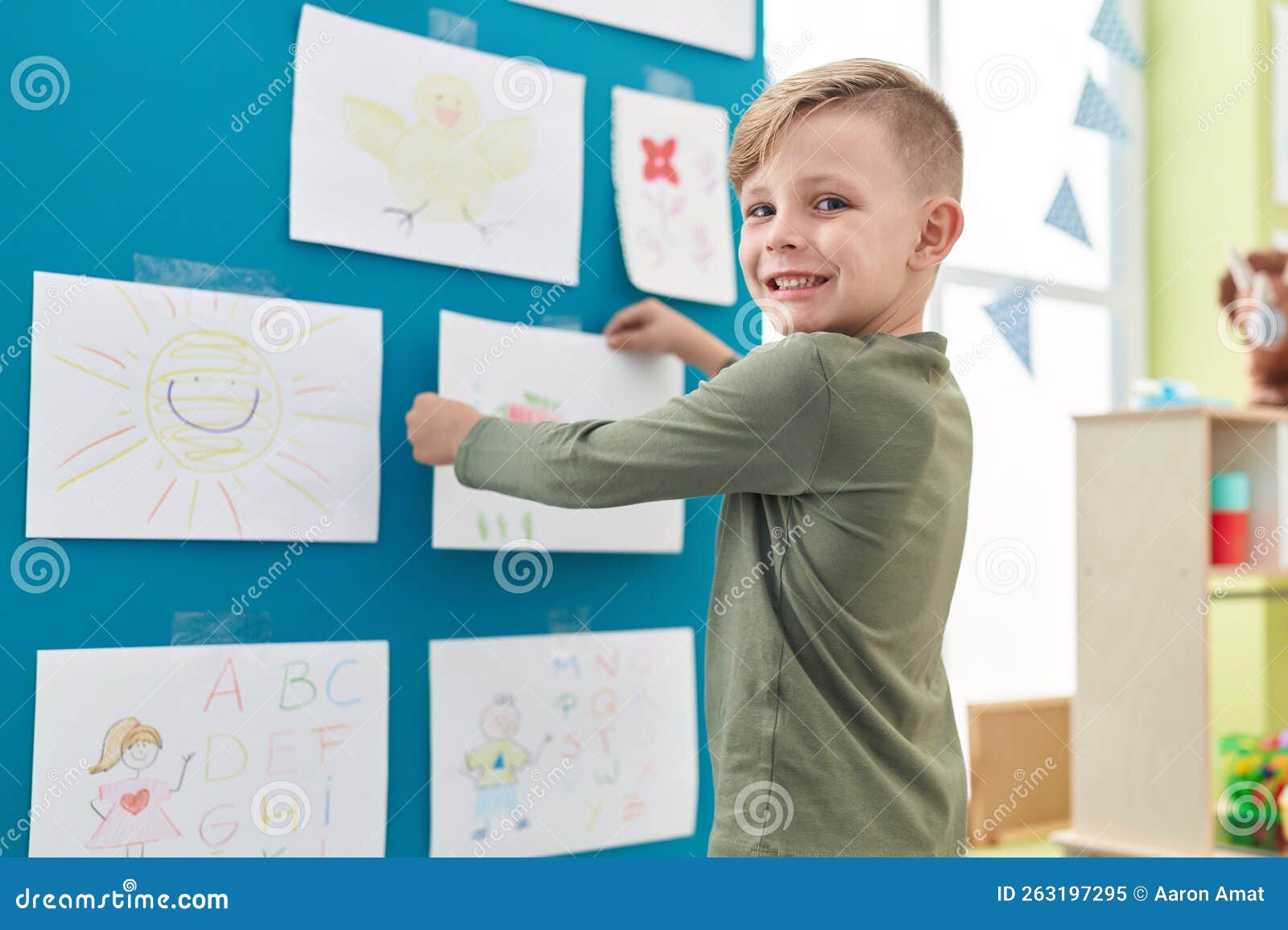Adorable Toddler Smiling Confident Hanging Draw on Wall at Classroom ...