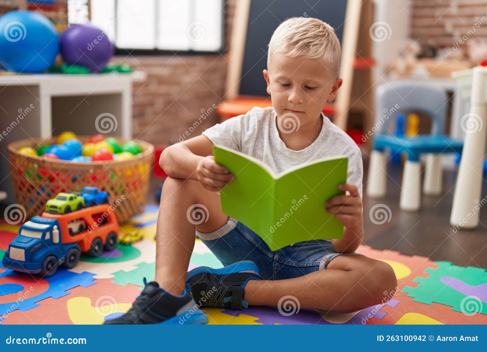 Adorable Toddler Student Reading Book Sitting on Floor at Classroom ...