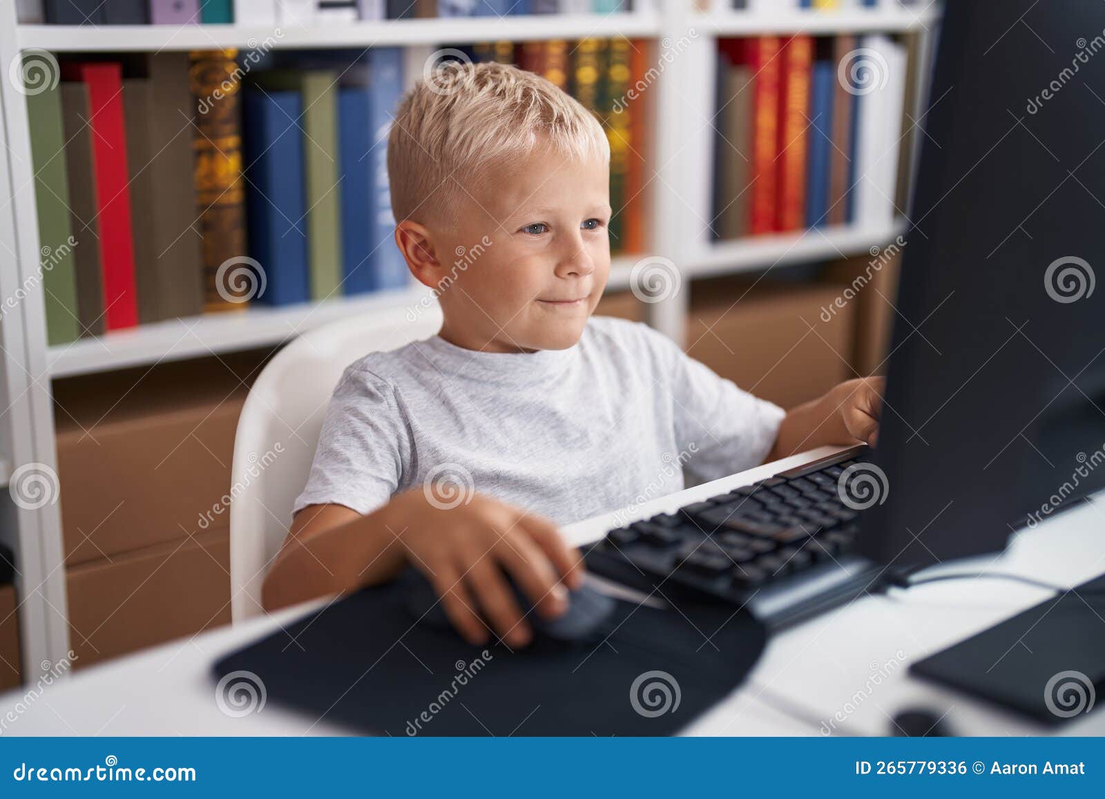 Adorable Toddler Student Using Computer Sitting on Table at Classroom ...