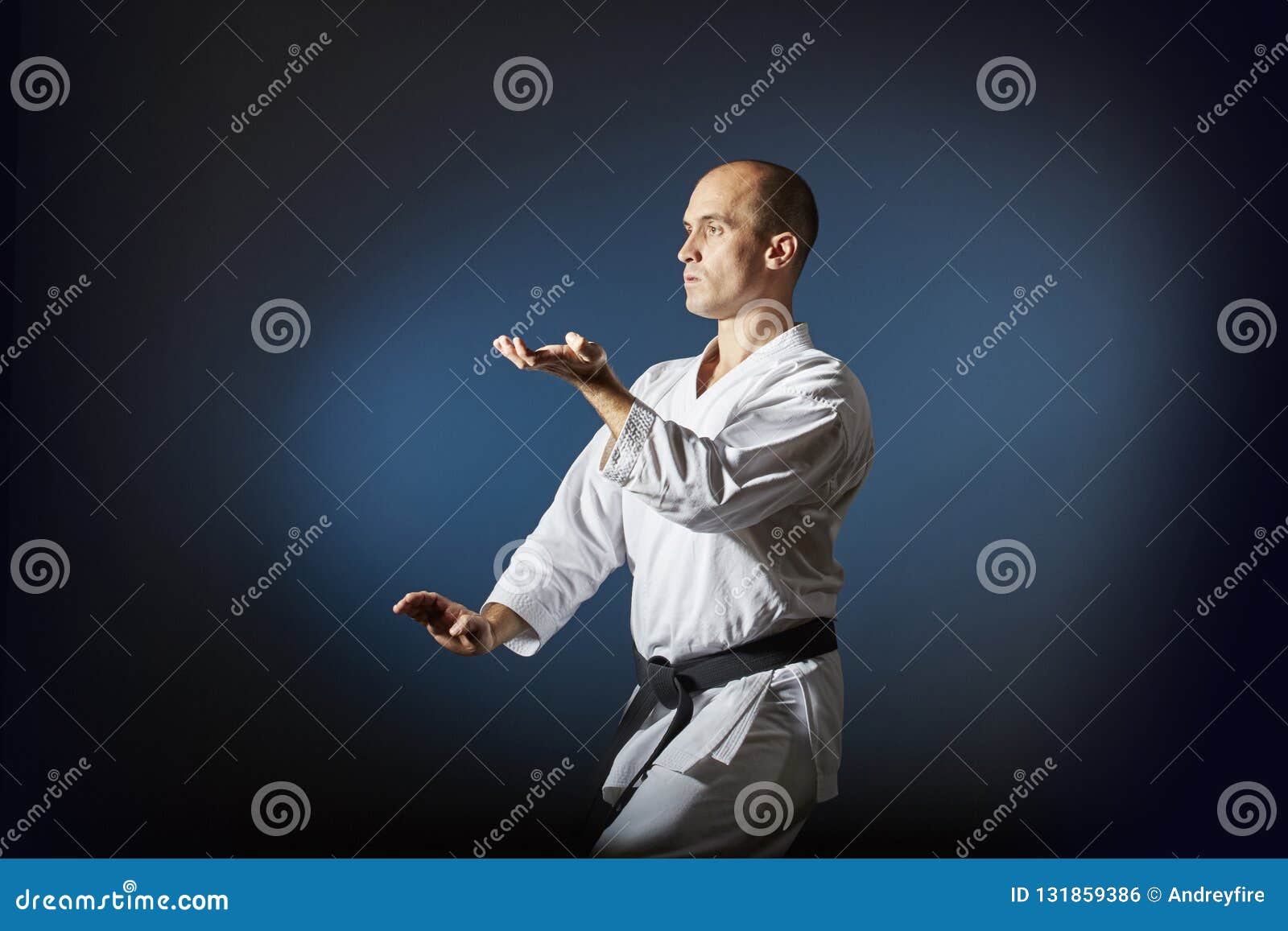 Adult Athlete Doing Formal Karate Exercises on Blue Background with ...