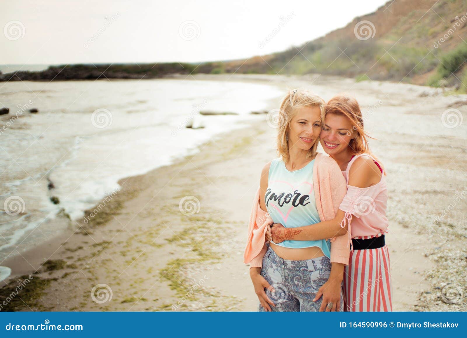 Adult Daughter And Mom Hugs On The Sea Shore And Both Are Smiling Stock