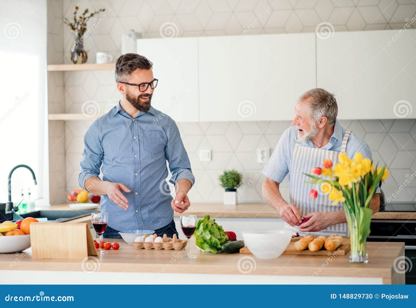 An Adult Hipster Son And Senior Father Indoors At Home Cooking Stock