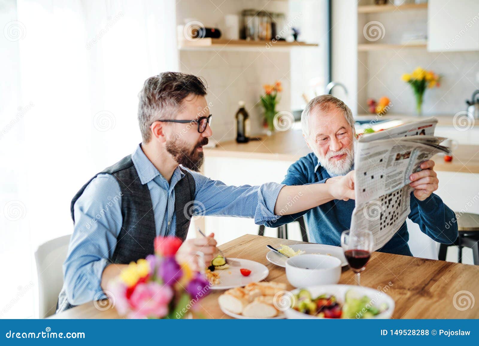 An Adult Hipster Son And Senior Father Indoors At Home Eating Light