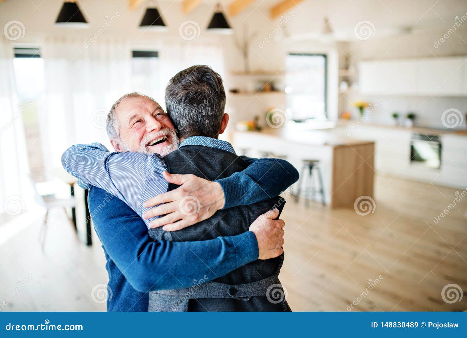 An Adult Hipster Son And Senior Father Indoors At Home Hugging Stock