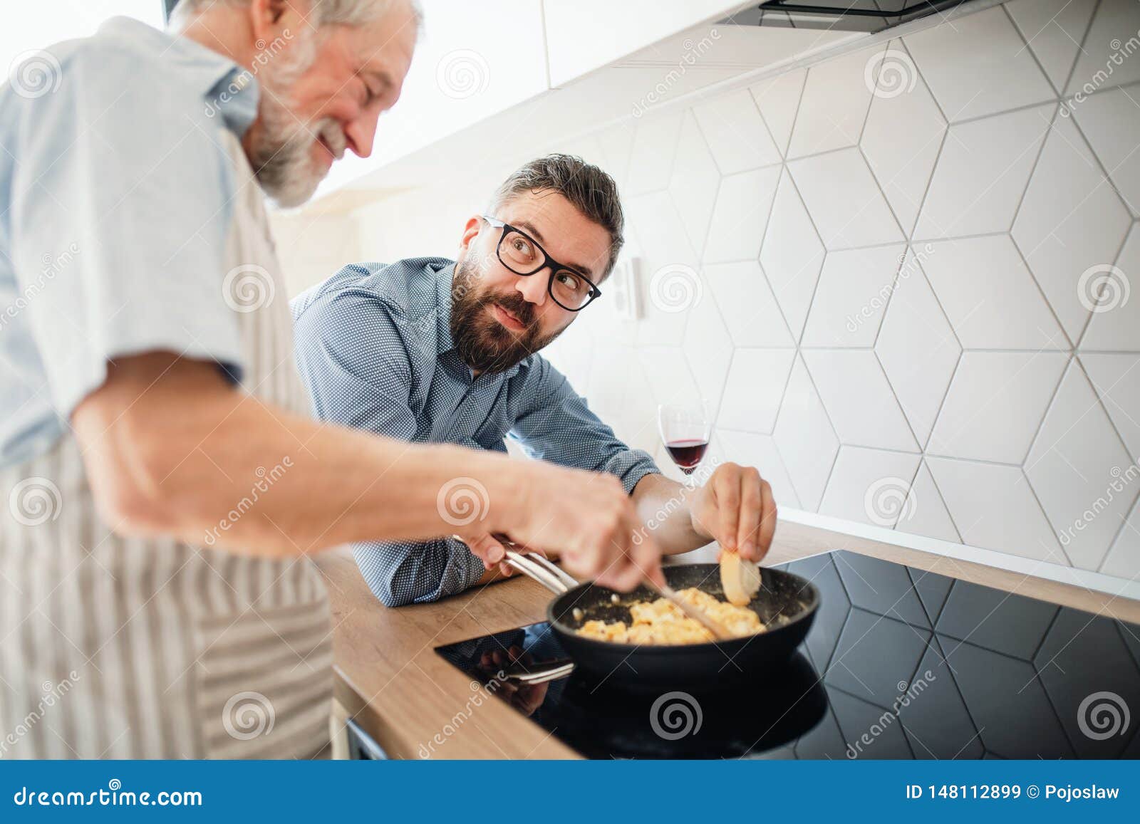 Adult Hipster Son And Senior Father Indoors In Kitchen At Home Cooking