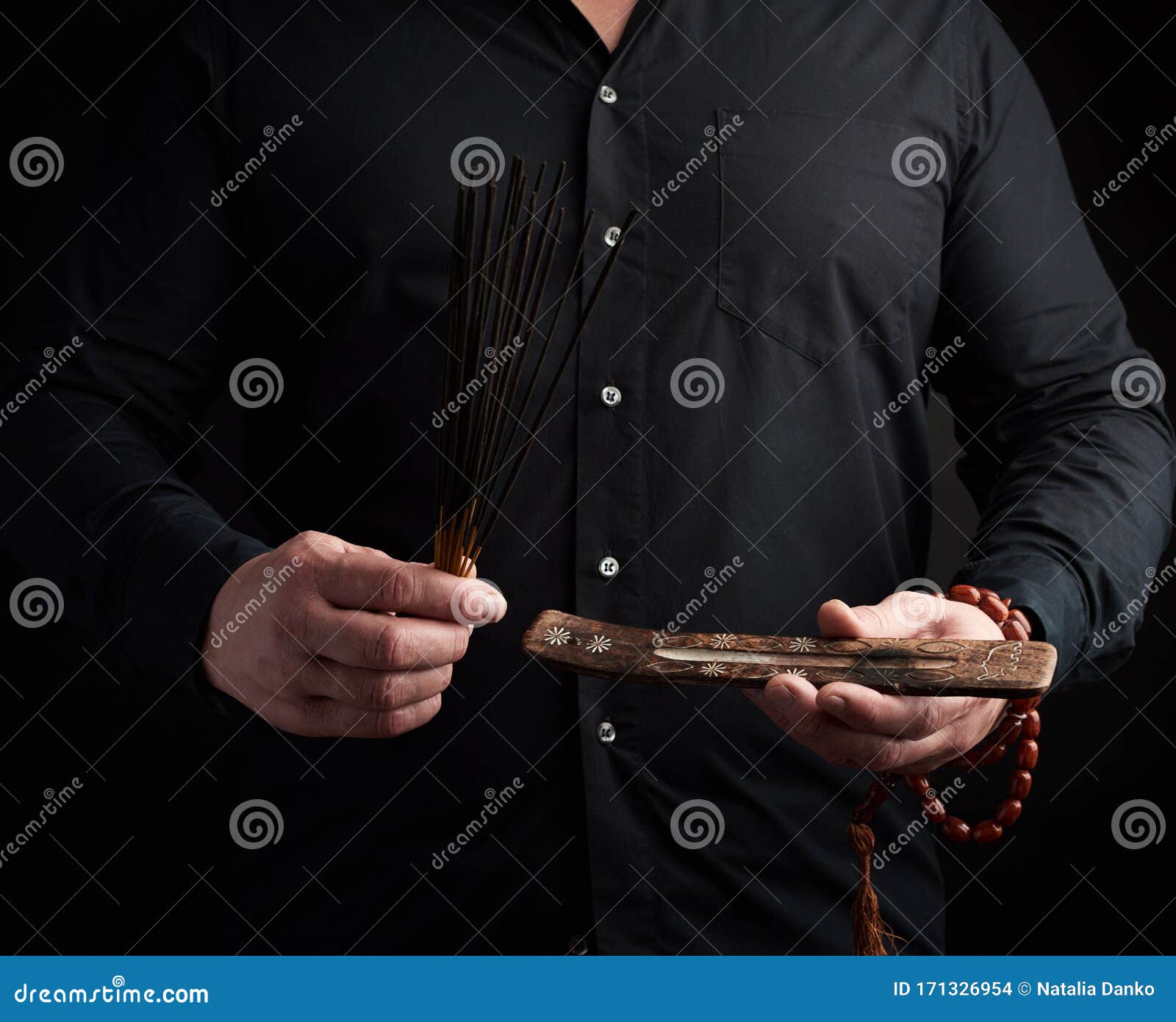 Adult Man in Black Clothes Holds a Stack of Incense Sticks Stock Photo ...