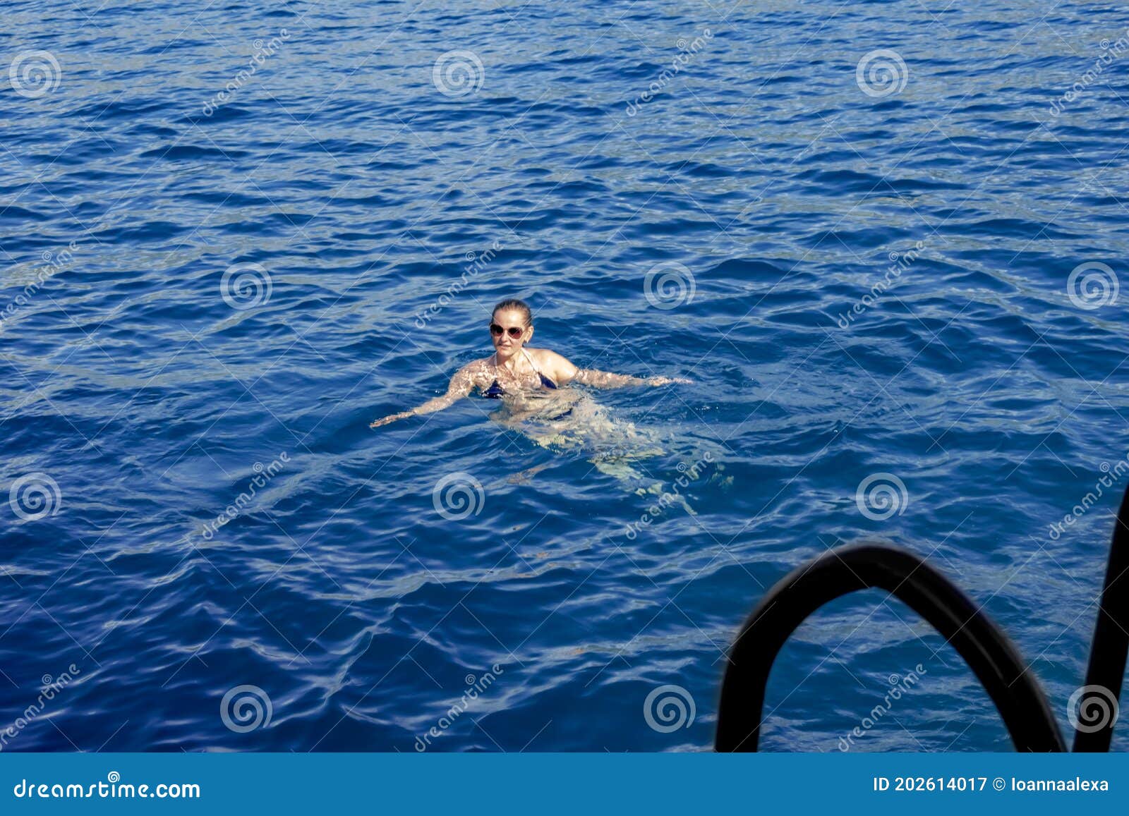 Adult Smiling Caucasian Girl Swims In Blue Water Young Woman In