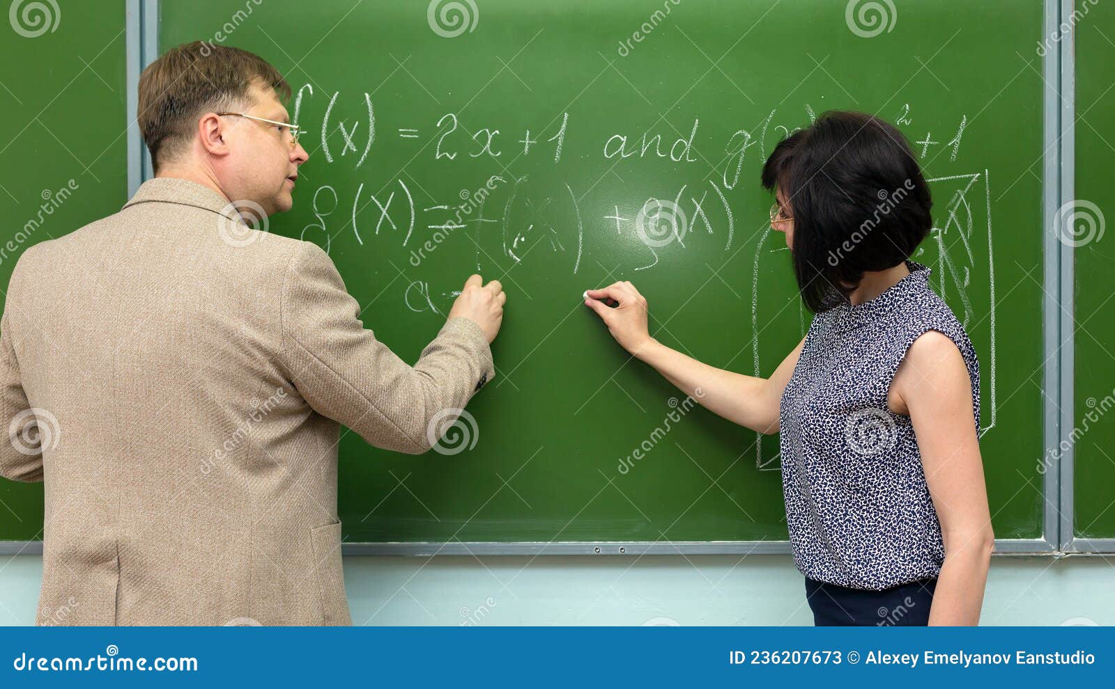 An Adult Teacher at the Blackboard Explains the Solution of a Math ...