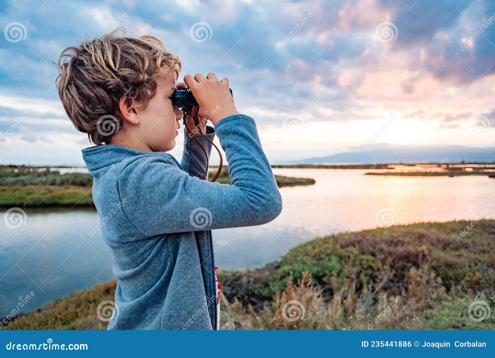 An Adventurous Boy Explores the Landscape with Binoculars with the ...