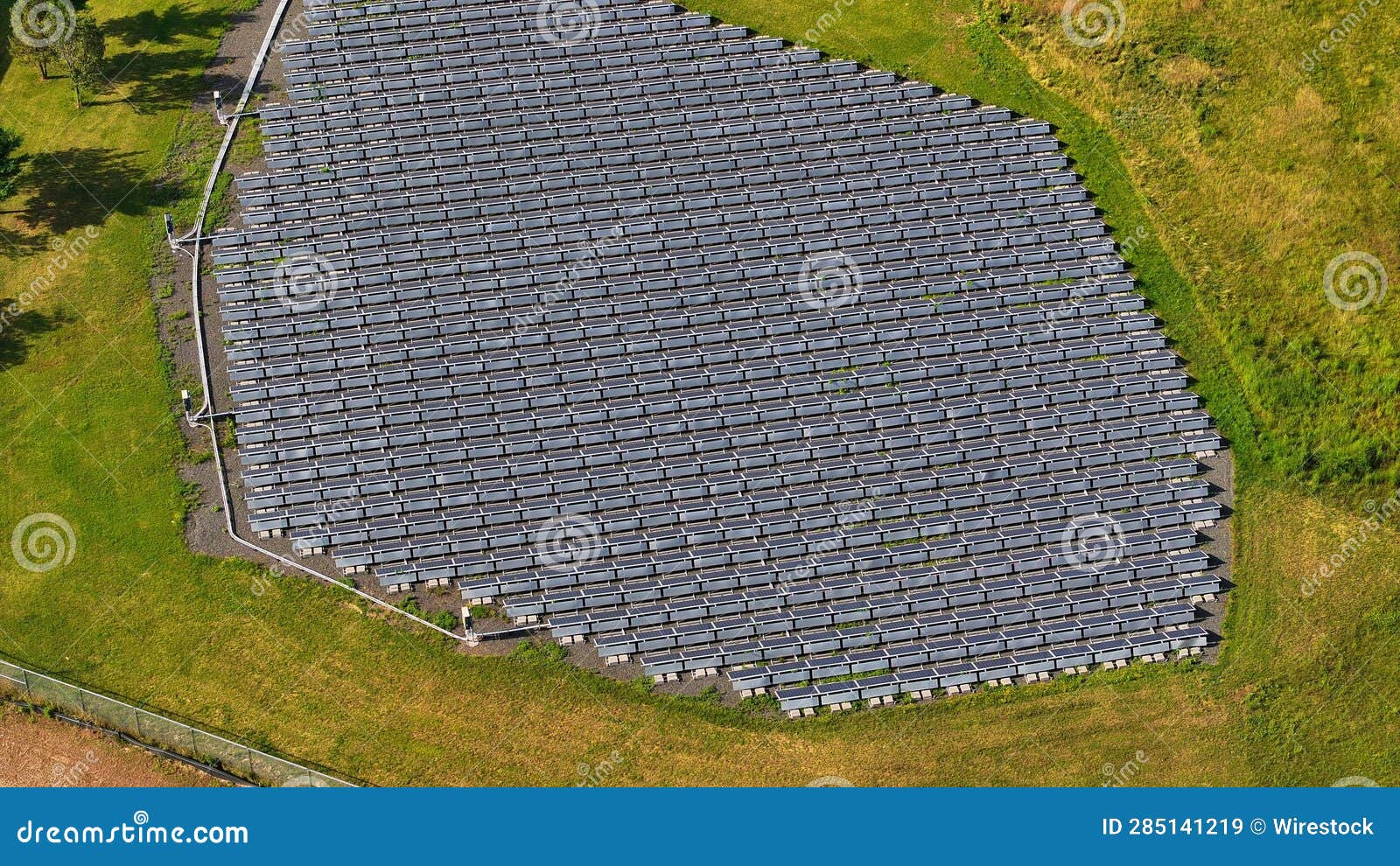 Aerial Shot of an Array of Solar Panels Set Up on a Grassy Meadow ...