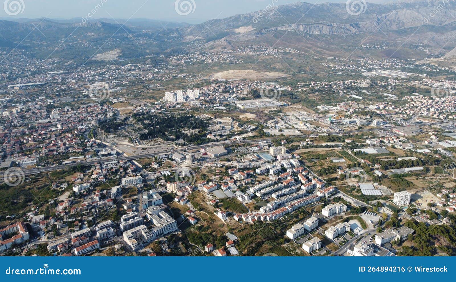 The Town Spread Out In A Valley Covered With Dry Yellow Grass, On Which ...