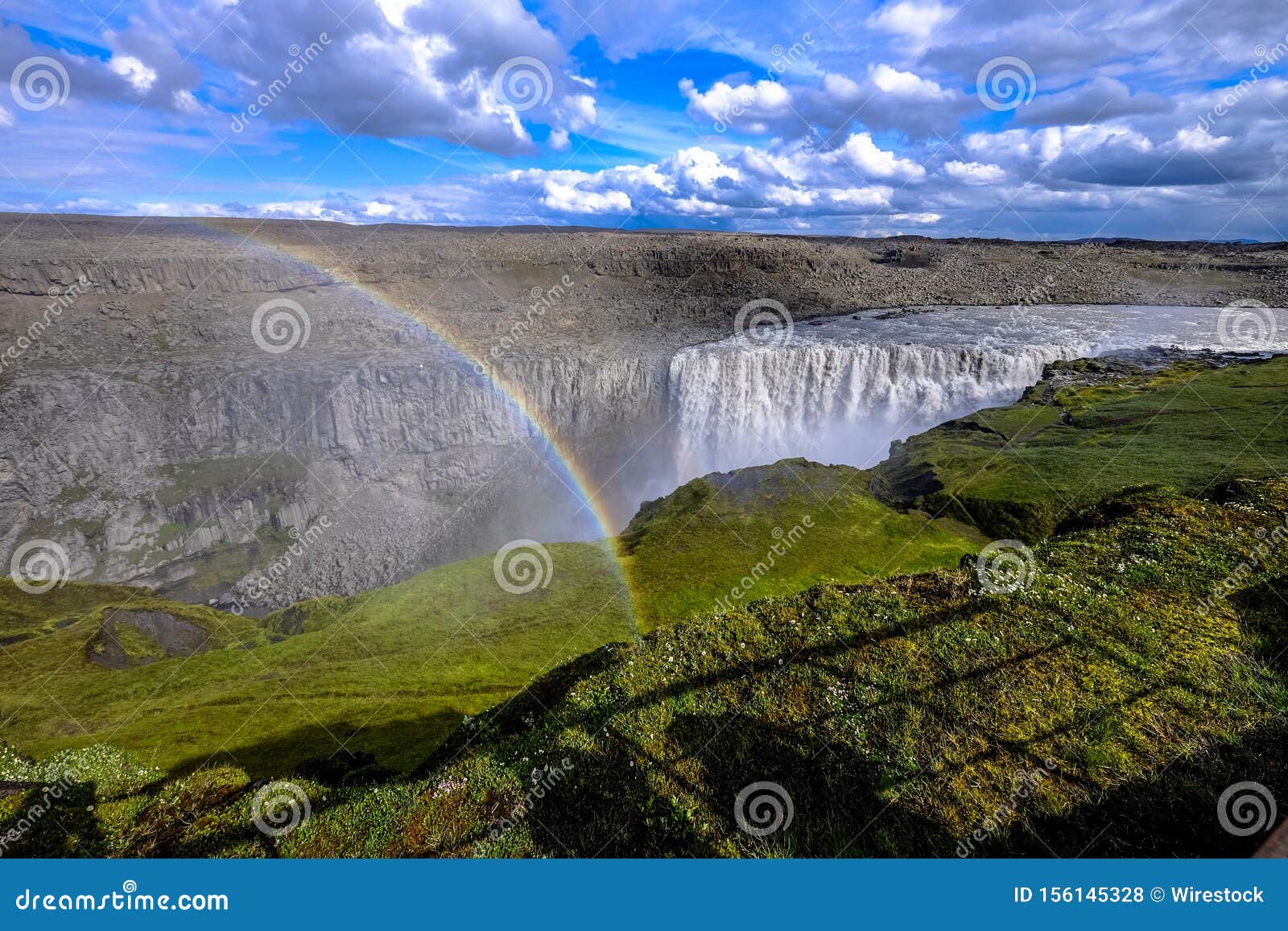 Aerial Shot of a Waterfall in the Middle of Cliffs and a Rainbow Over ...