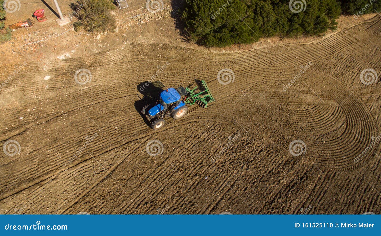 Aerial View of Blue Tractor in Operation Crushing the Ground after ...