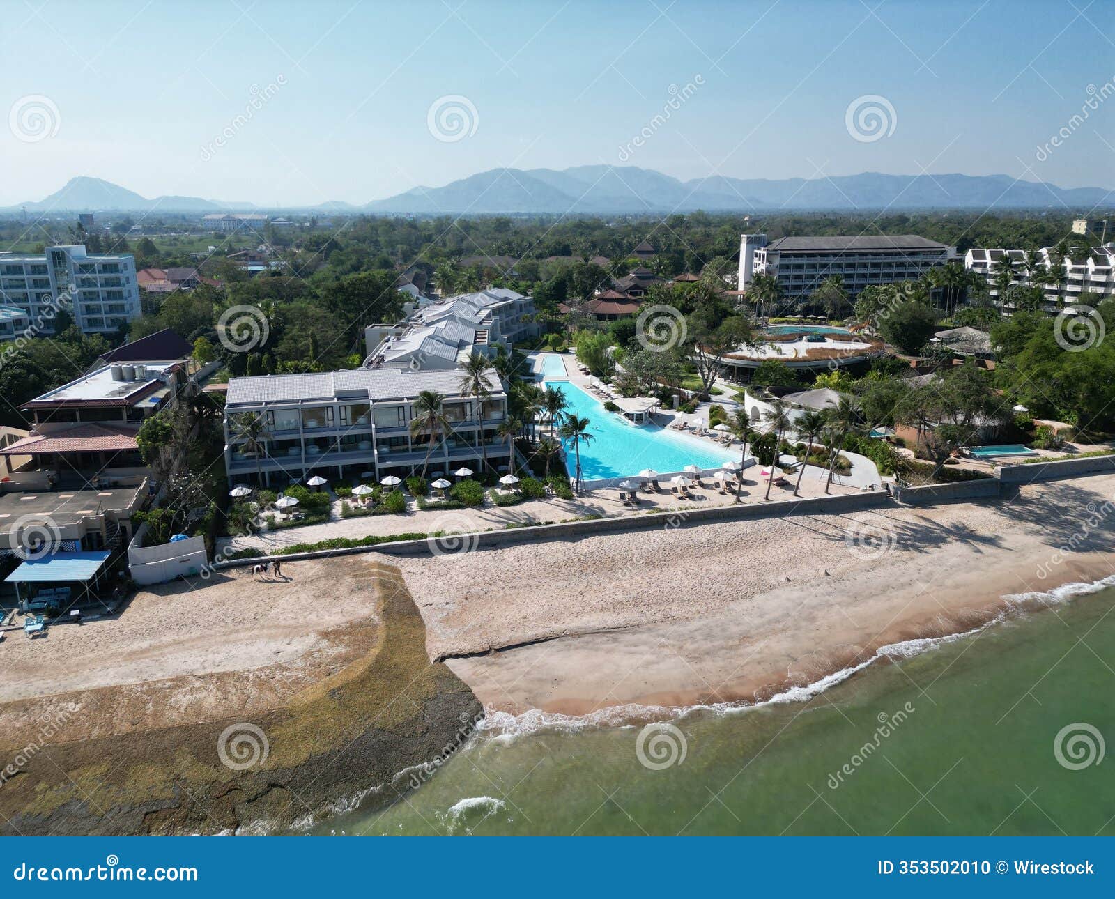 Aerial View that Captures the Ocean, Hotel and Trees with the Mountains ...