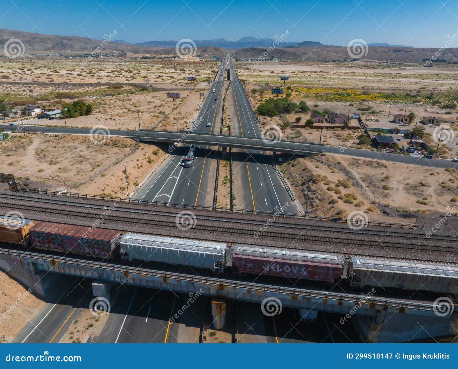Aerial View of Desert Highway Interchange with Train Tracks and Rugged ...