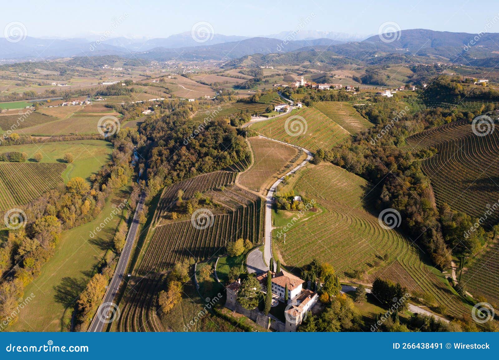 Aerial View of a Green Grass Field and a Road Surrounded by a Mountain ...
