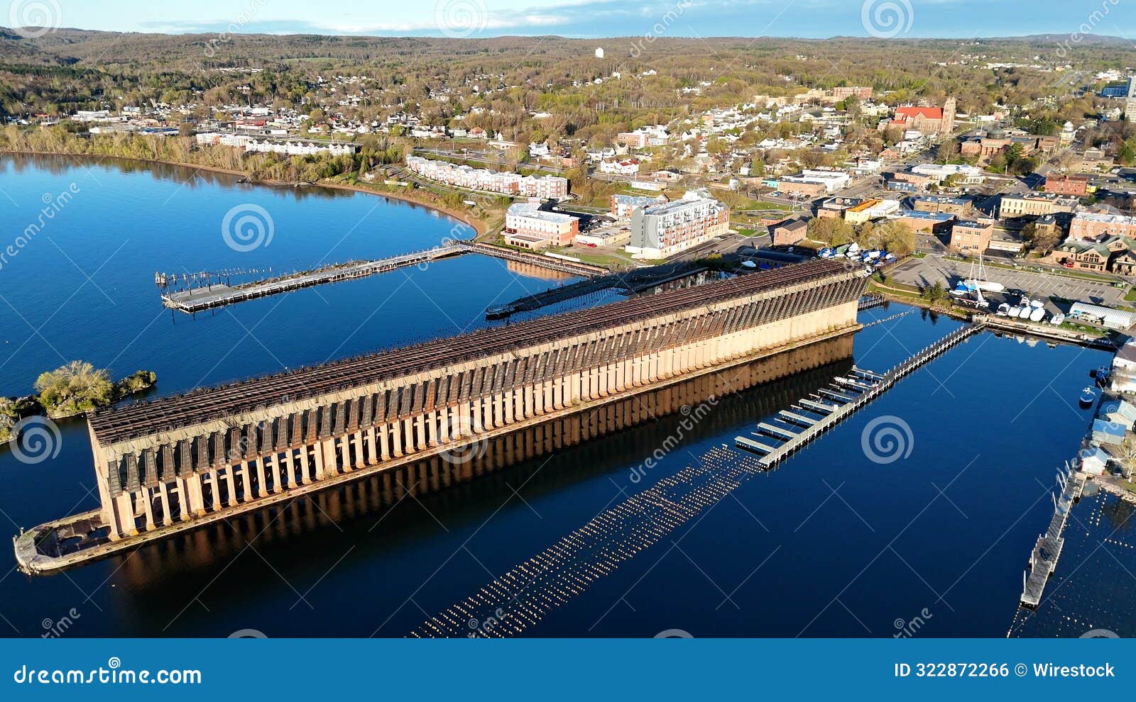 An Aerial View of a Large Dock with Arch Structures with a Cityscape ...