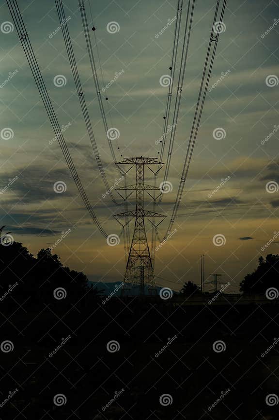 Aerial View of a Power Line Illuminated at Dusk, Surrounded by a Vast ...