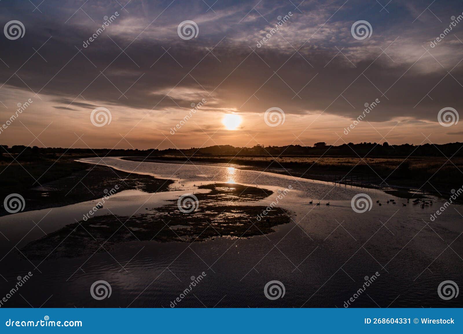 Aerial View of a River at Sunset with a Cloudy Sky in the Background ...