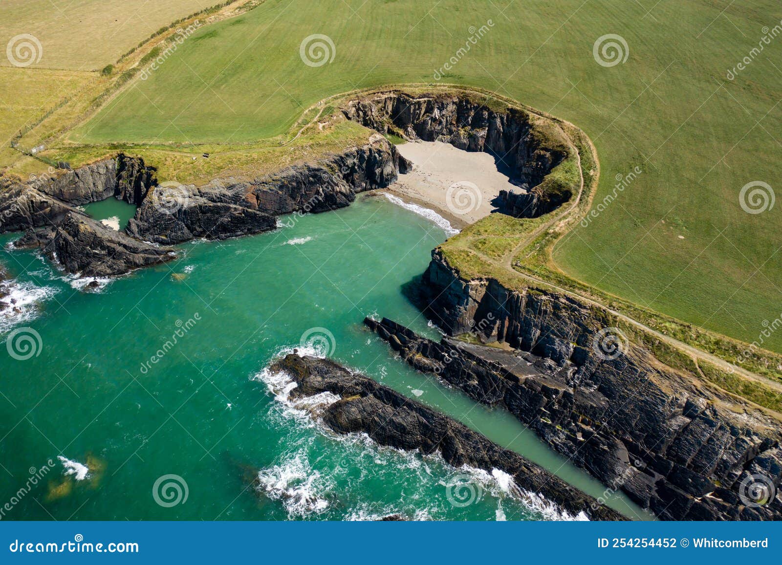 Aerial View of a Tiny Sandy Beach Surrounded by Cliffs on the Coast of ...