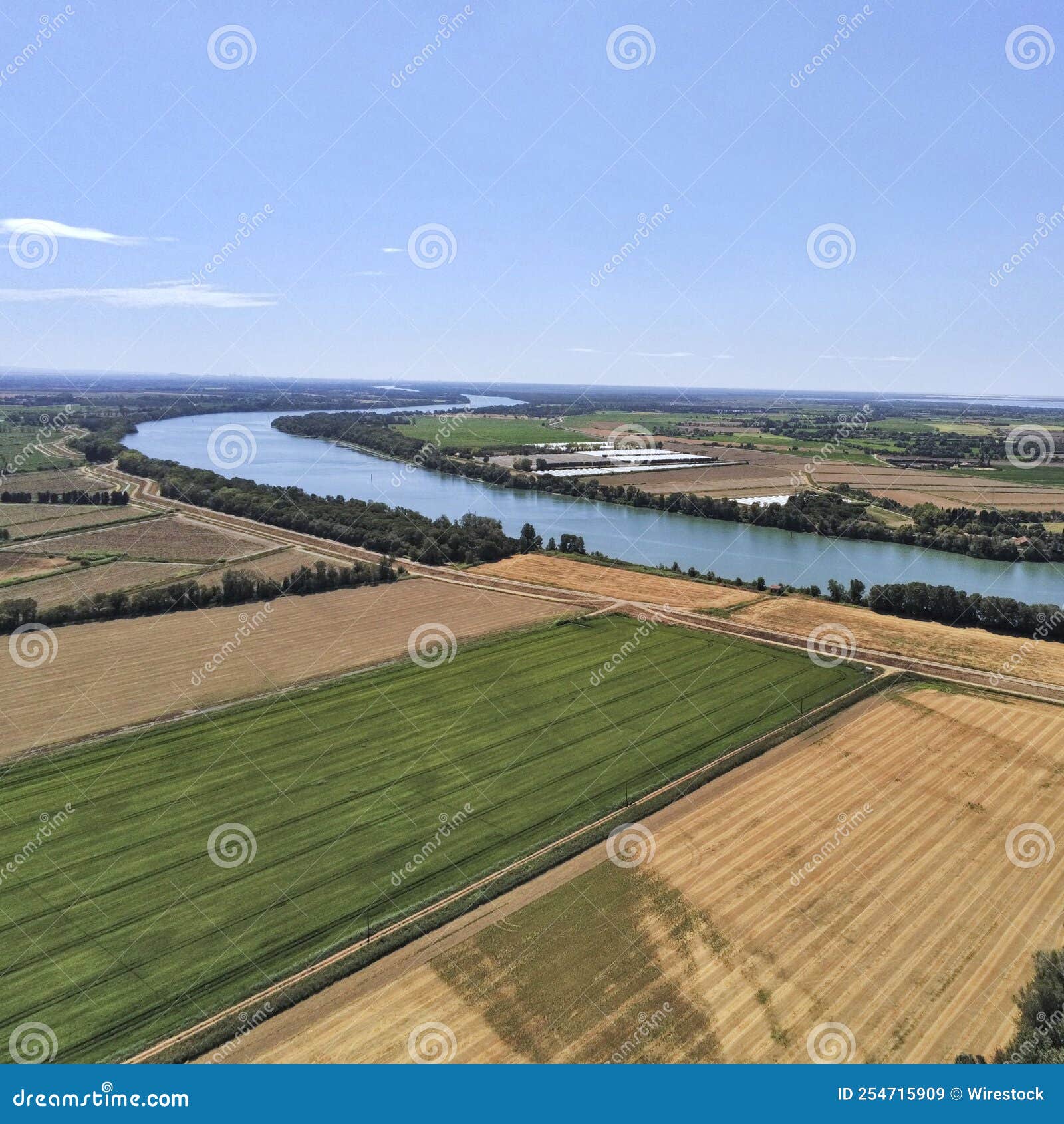 Aerial View of Wheat and Grass Fields with a River Flowing in the ...