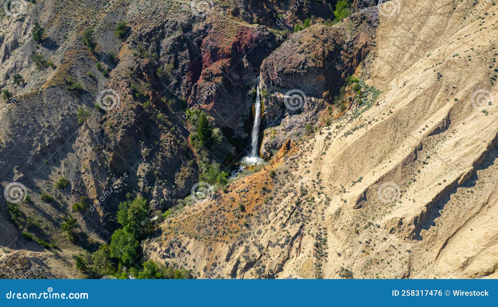 Aerial of a Waterfall Cutting through a Mountain and Spilling into a ...