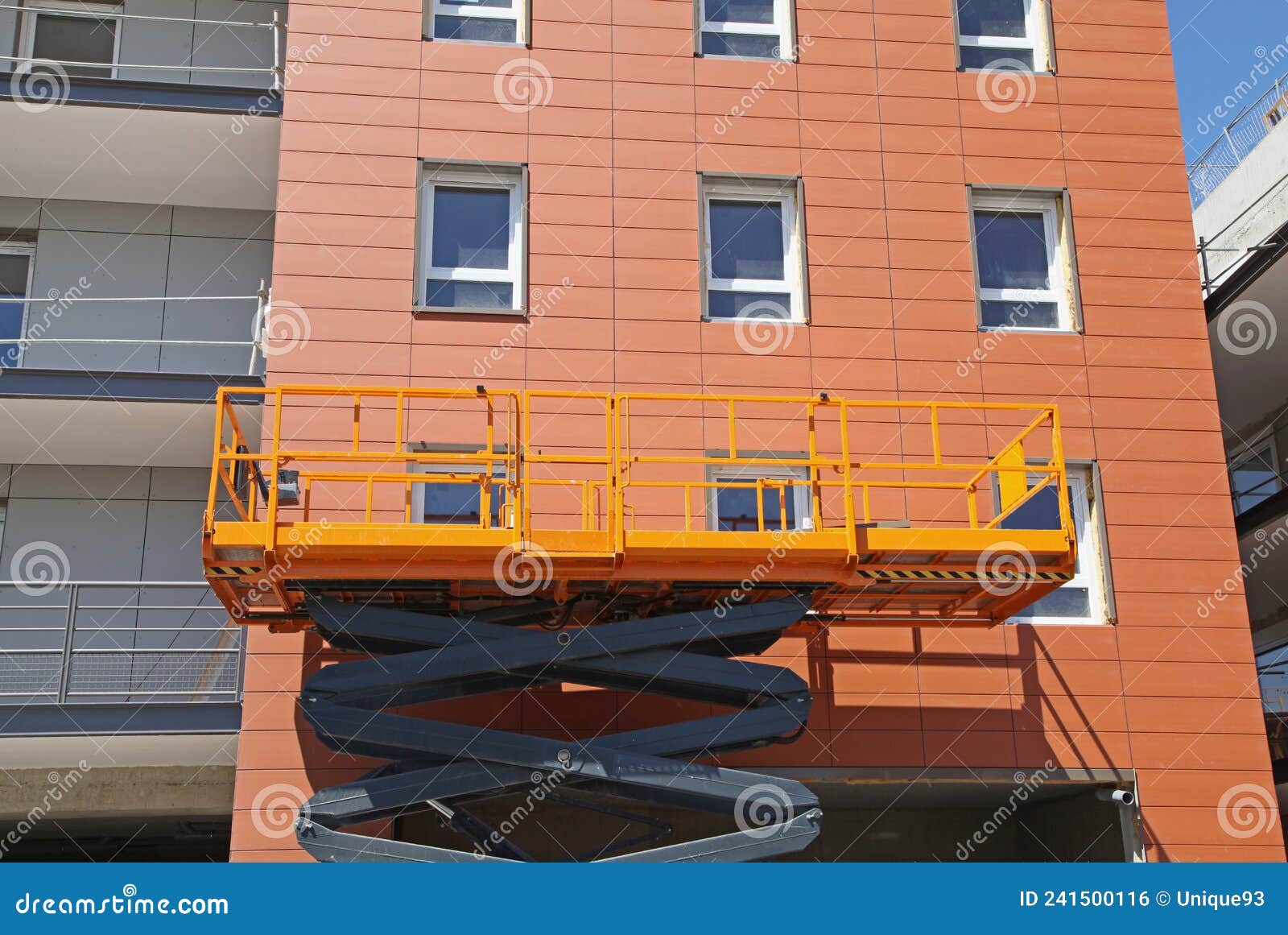 Aerial Work Platform in Front of a Siding Installation Site of a ...