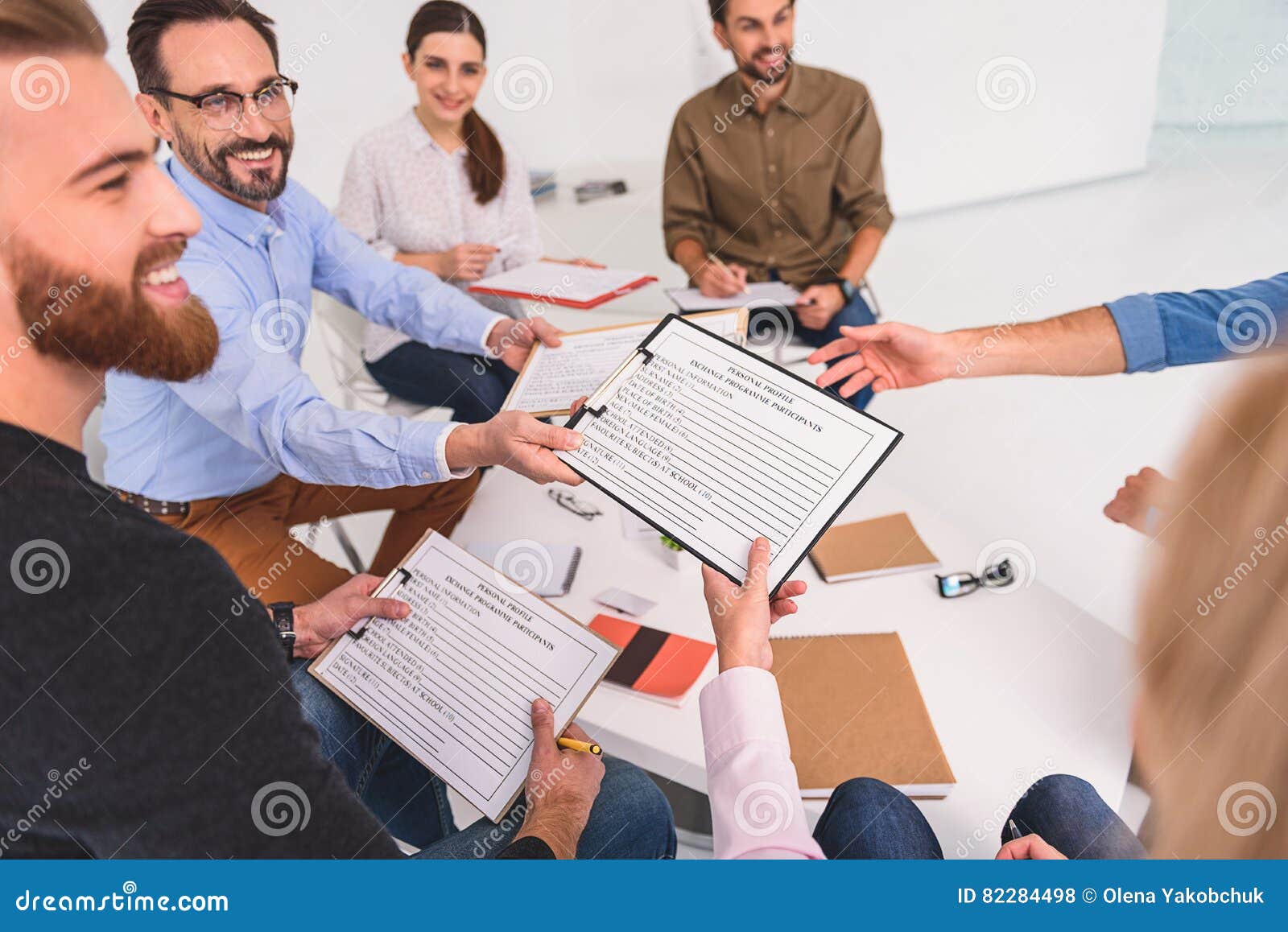 Affable Man Giving Forms To People Stock Photo - Image of cheer, group ...