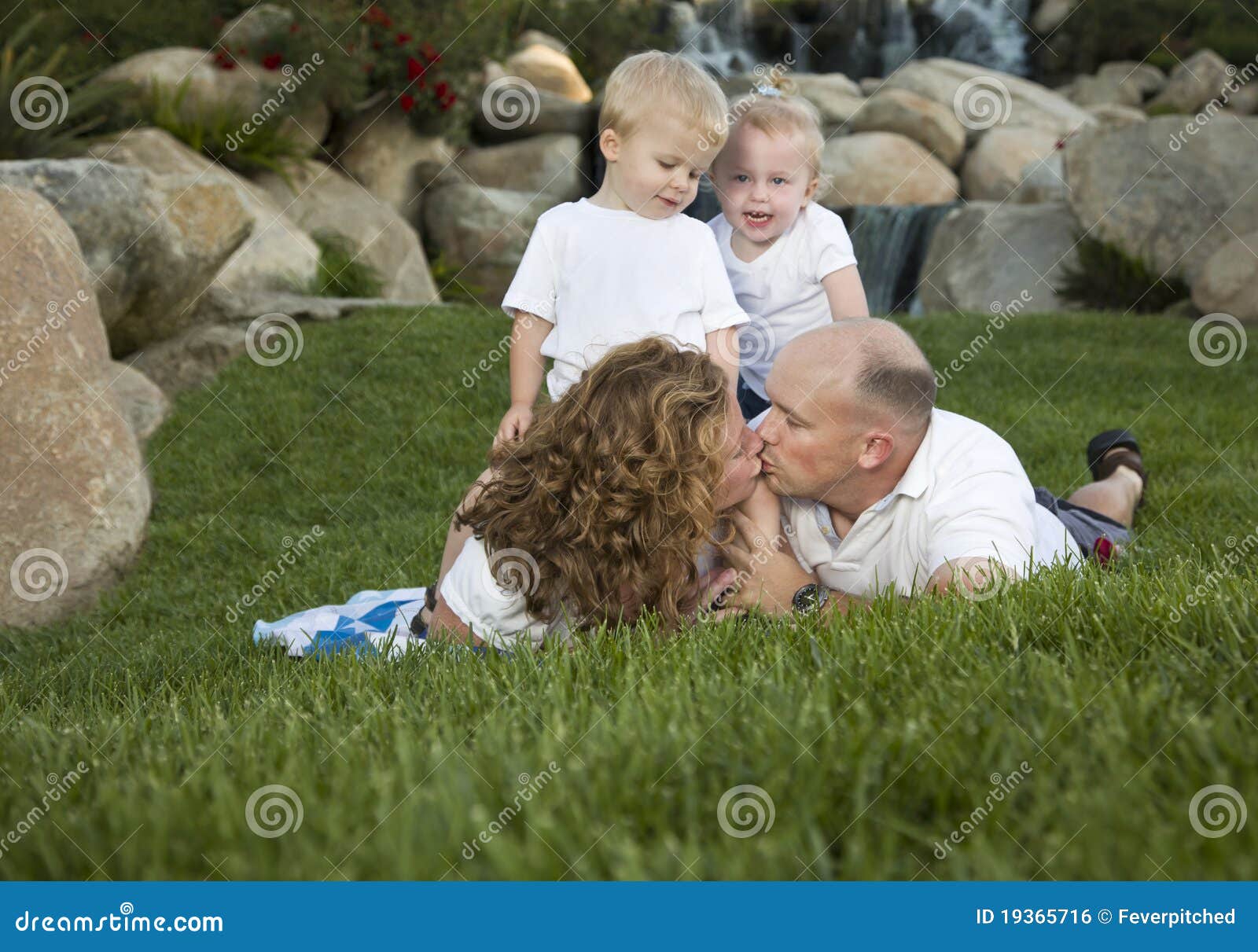 Affectionate Couple Kiss As Cute Twins Look on Stock Photo - Image of ...