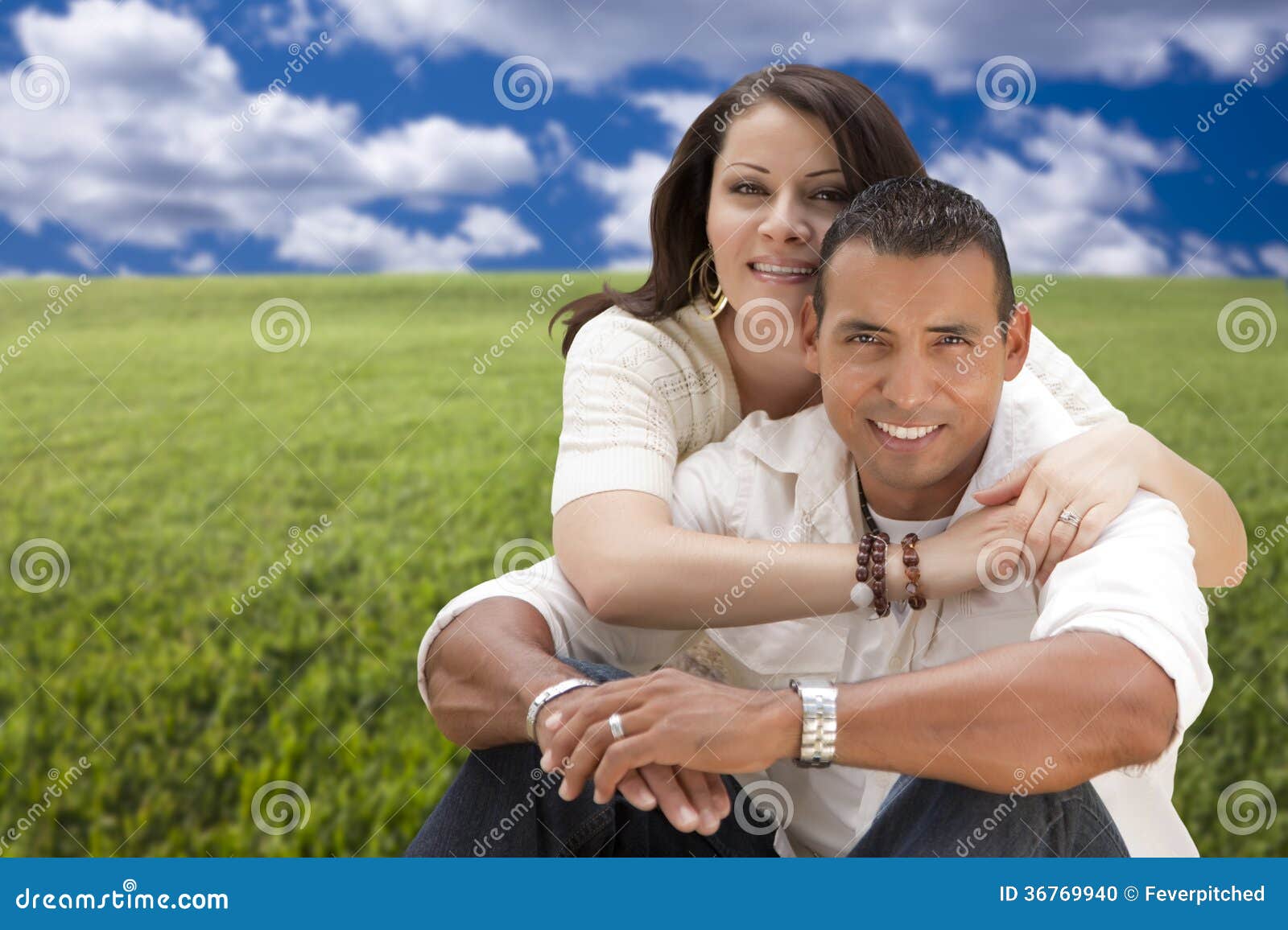 Affectionate Hispanic Couple Hugging in Grass Field Stock Photo - Image ...