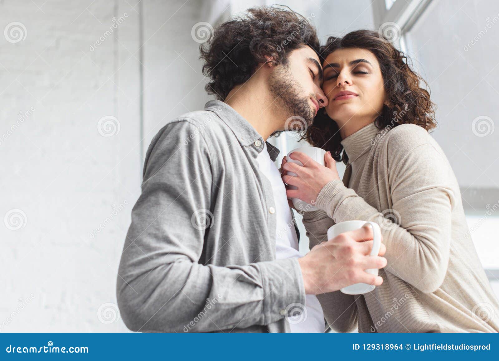 Affectionate Young Couple Cuddling on Windowsill Stock Photo - Image of ...