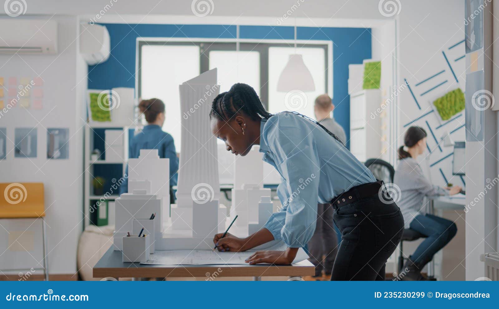 African American Architect Analyzing Blueprints Plan and Building Model ...