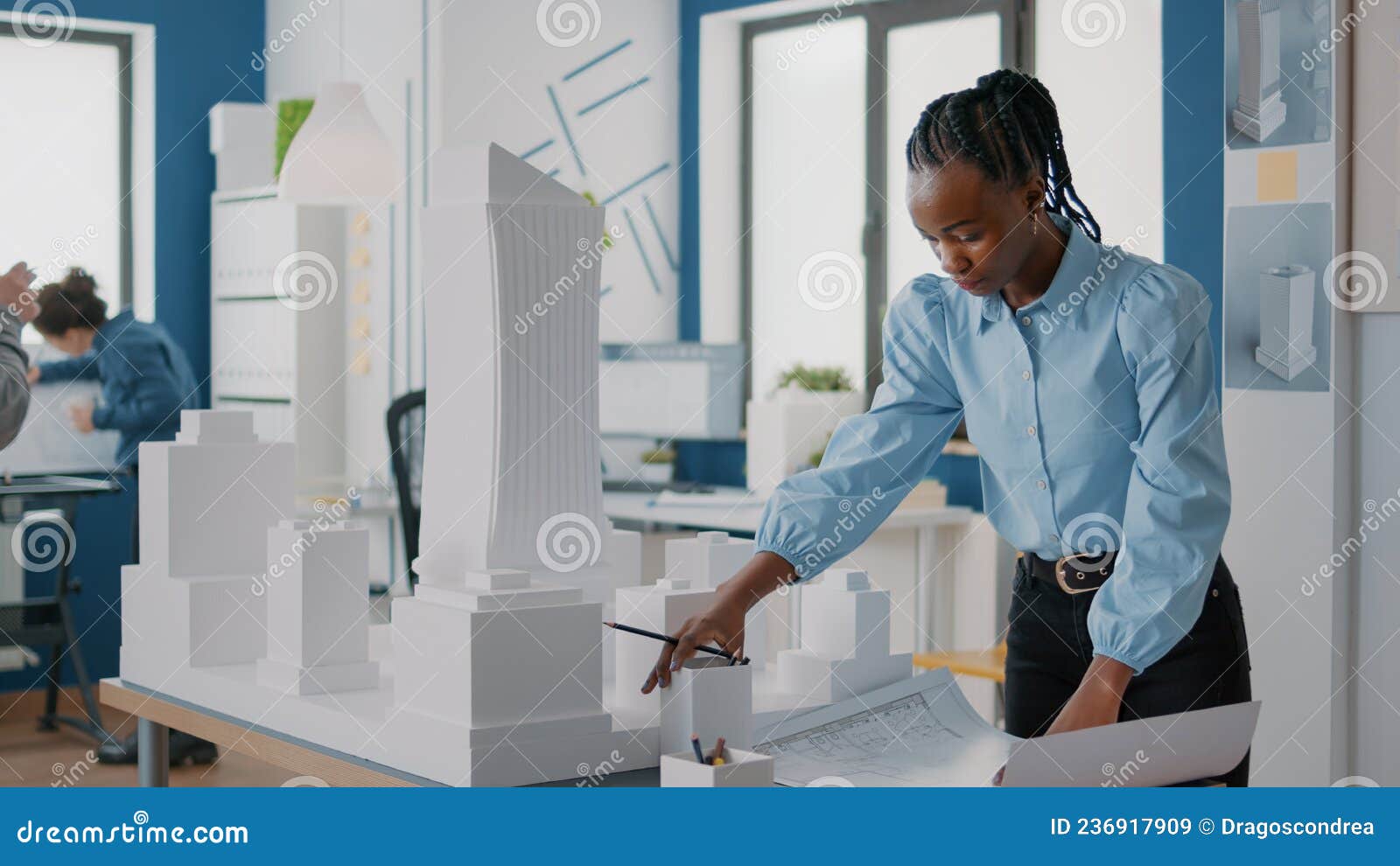 African American Architect Analyzing Blueprints Plan and Building Model ...