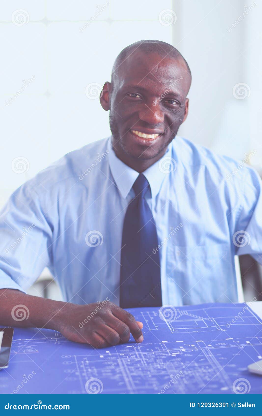 African American Architect Working with Computer and Blueprints in ...