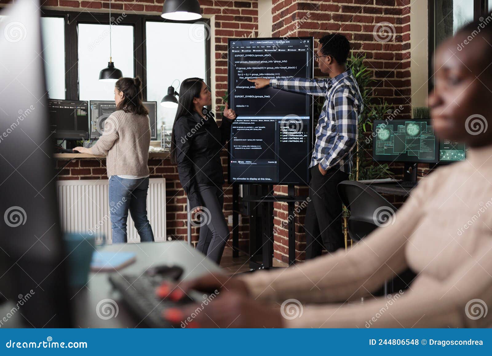 African American Back End Network Developer Explaining To Coworker Application Lines of Code ...