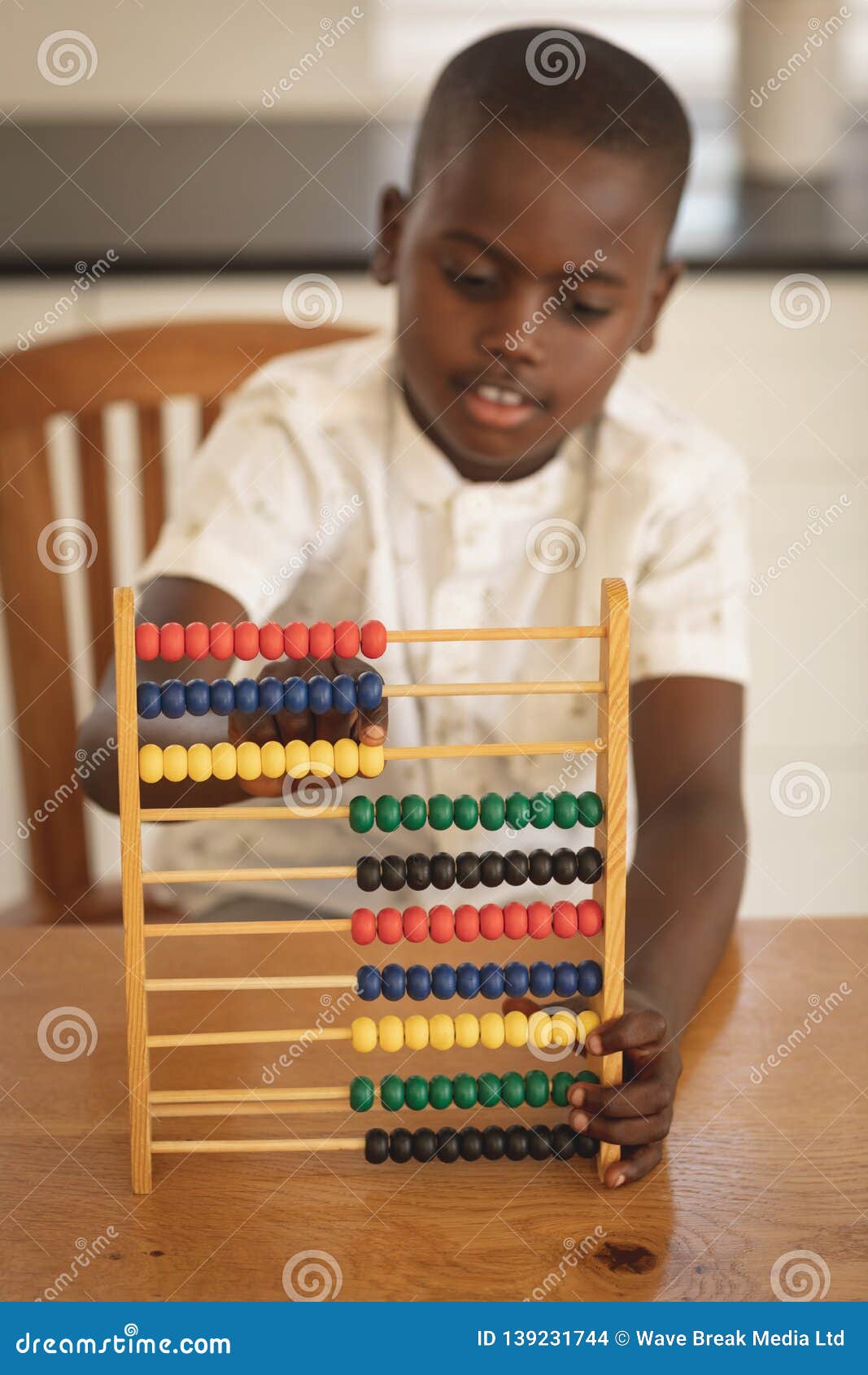 African American Boy Learning Mathematics with Abacus on Dining Table ...