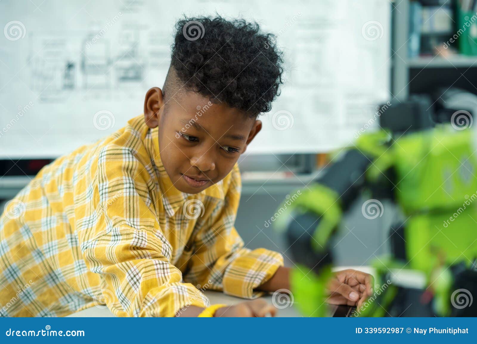 An African American Boy is Using Laptop Computer Programming Robot Kit ...