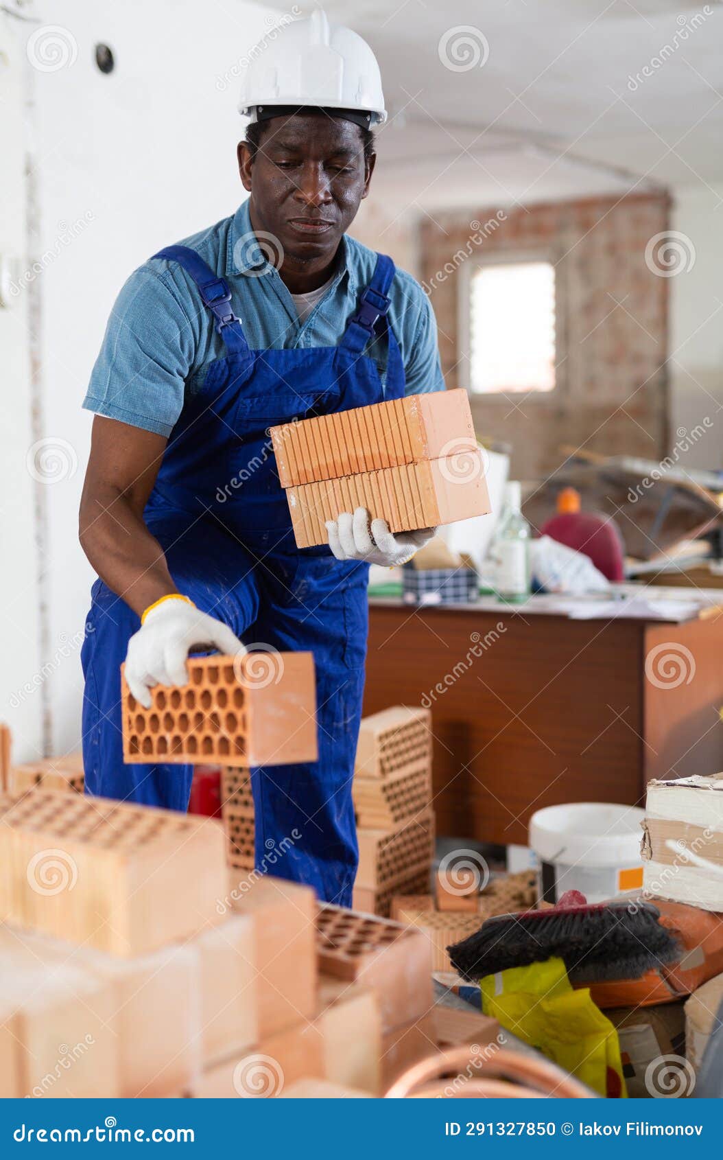 African American Builder Stacking Bricks in Building Under Renovation ...