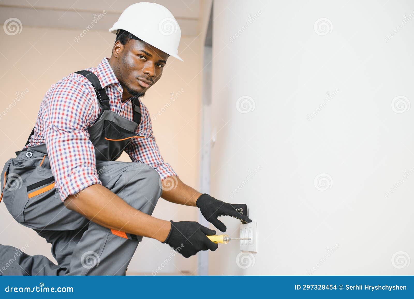 African-American Electrician Using Socket Voltage Regulator in Room ...