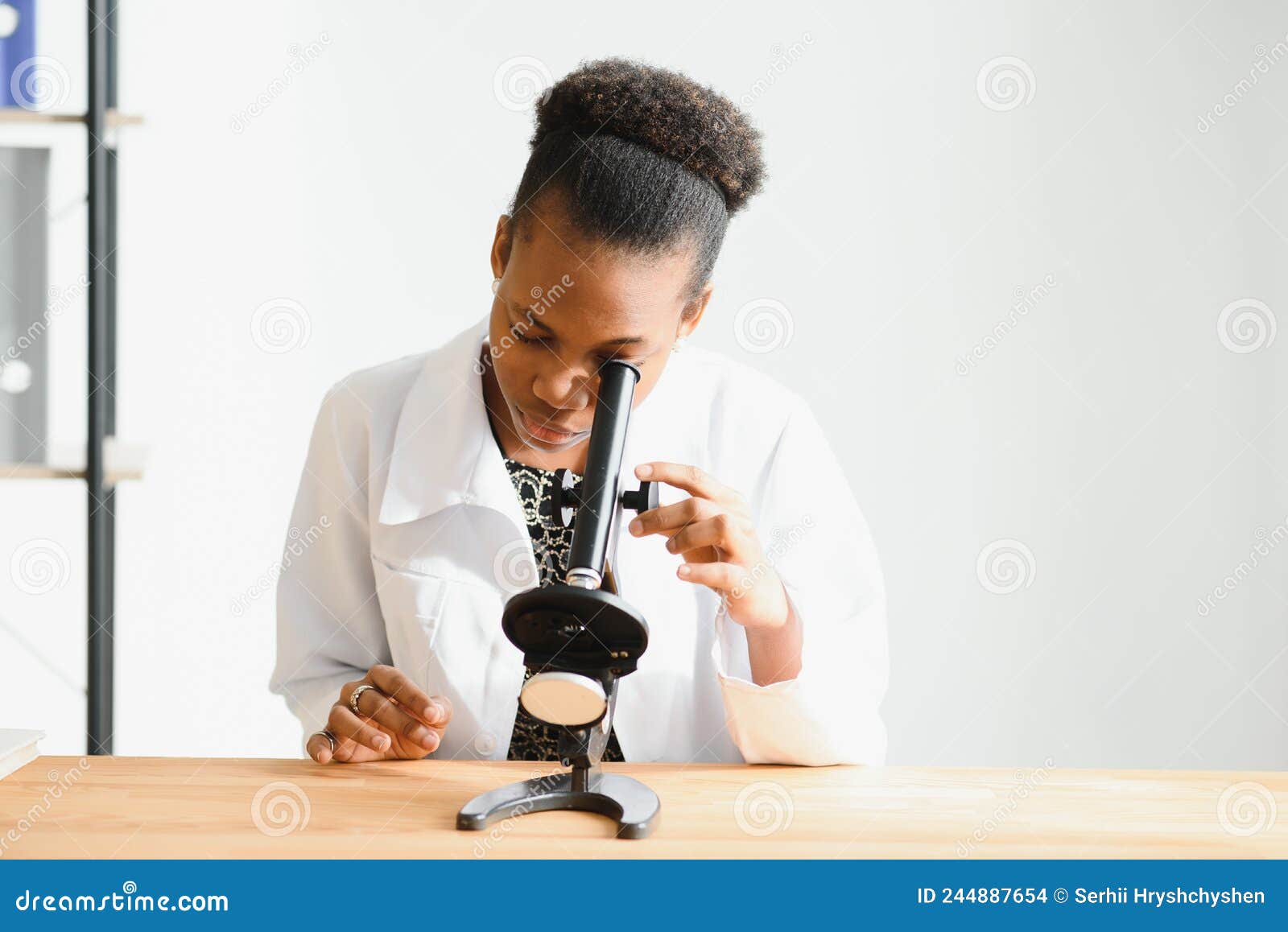 African American Female Lab Technician Looking through Microscope in ...