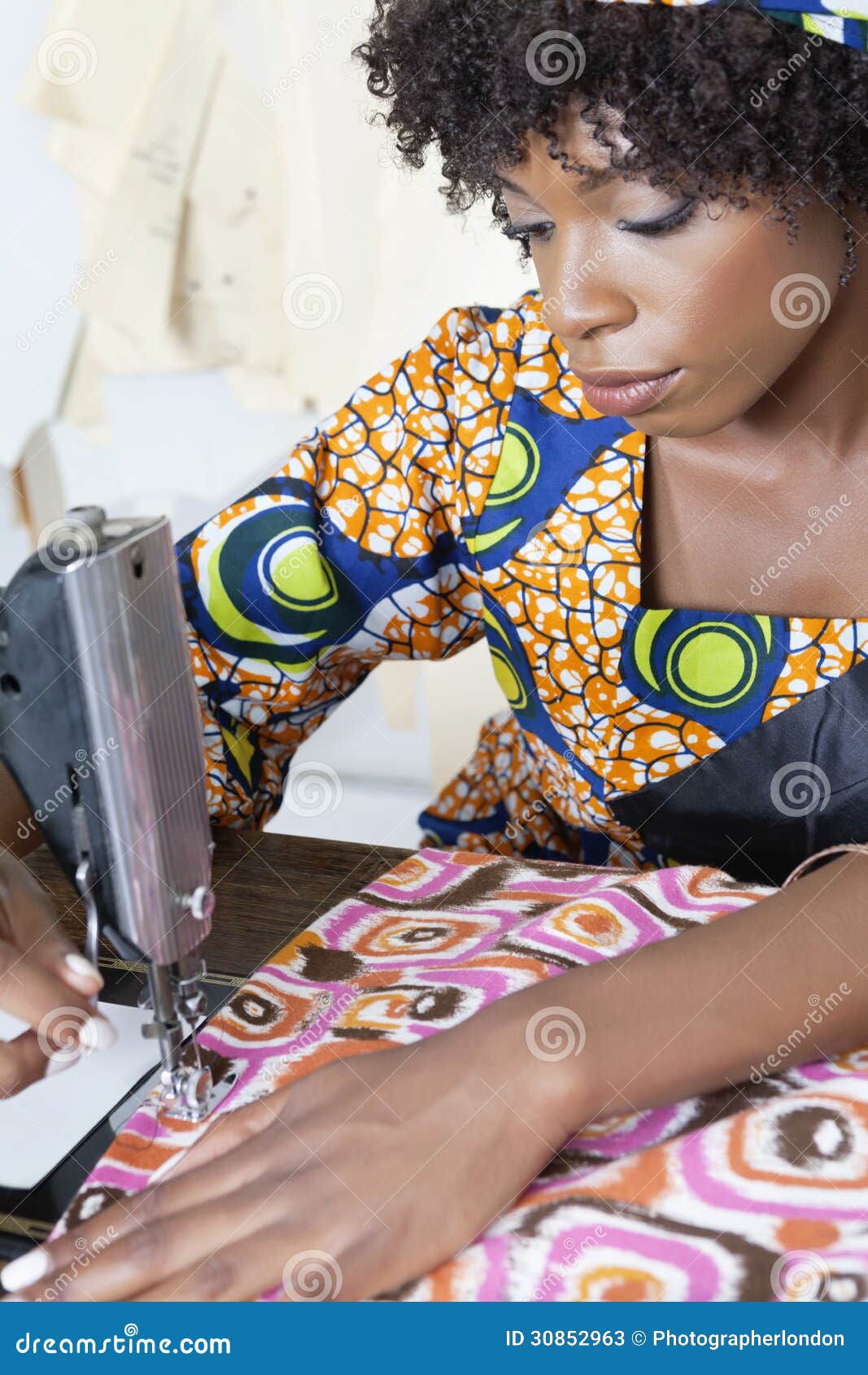 African American Female Tailor Stitching Patterned Cloth On Sewing