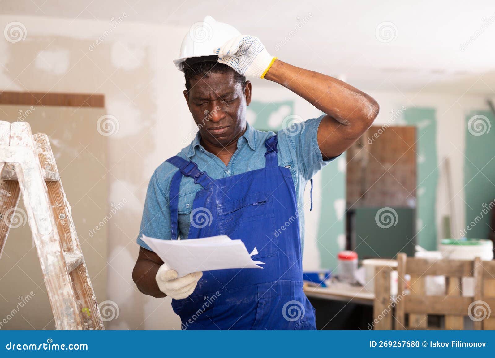 African American Foreman Examines Documents and Plans a Workflow for ...