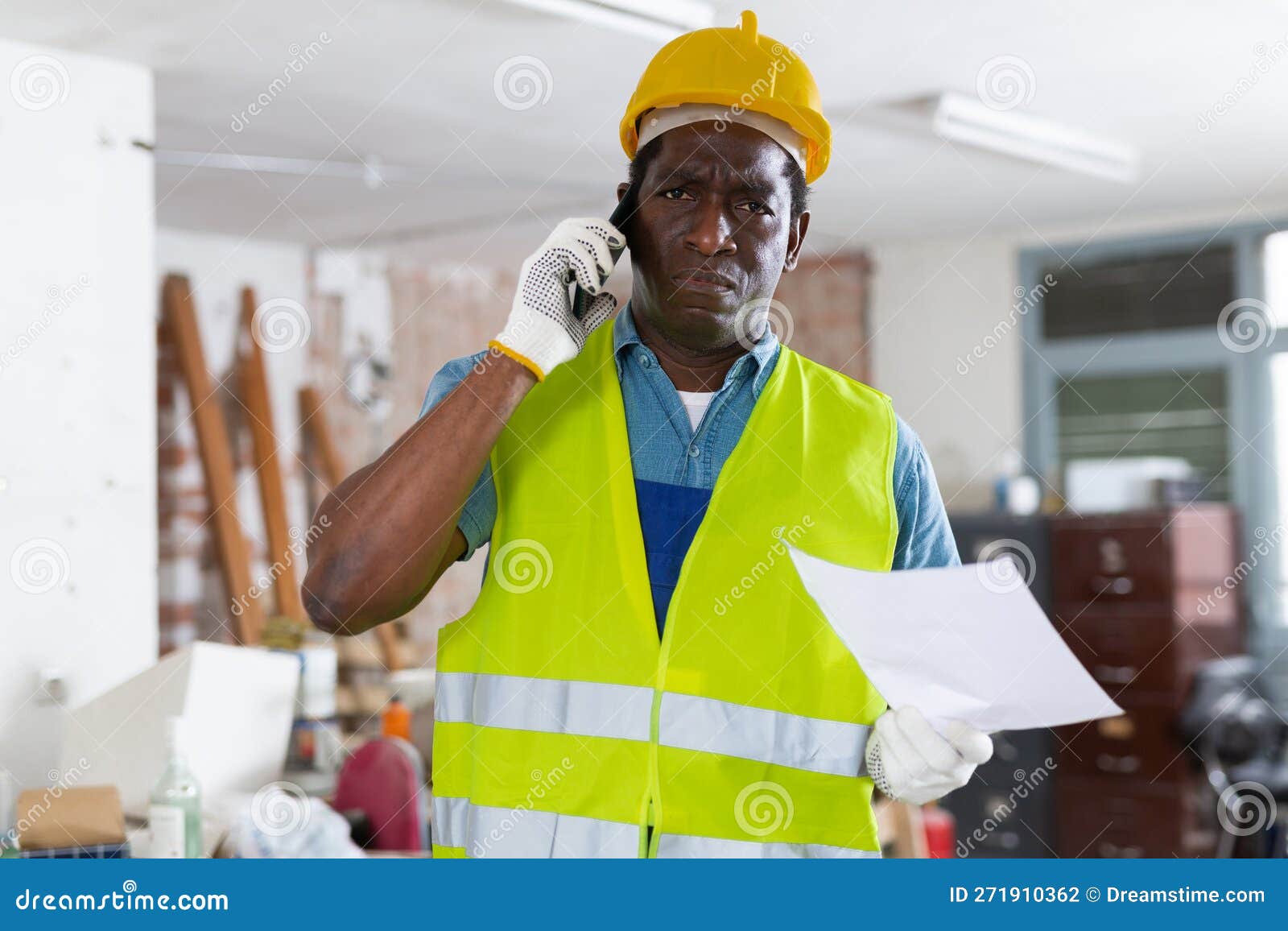 Foreman Holding Document in Hand and Talking on Phone in Construction ...
