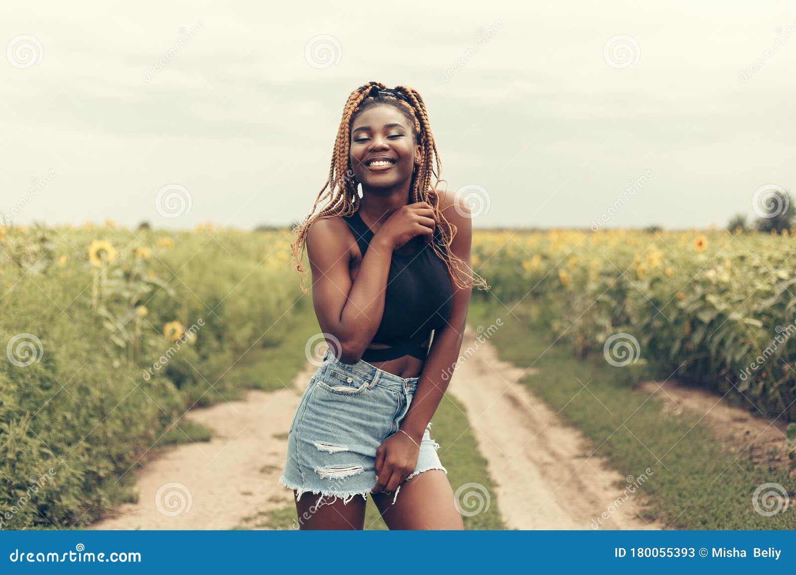 African American Girl In A Field Of Yellow Flowers At Sunset Stock